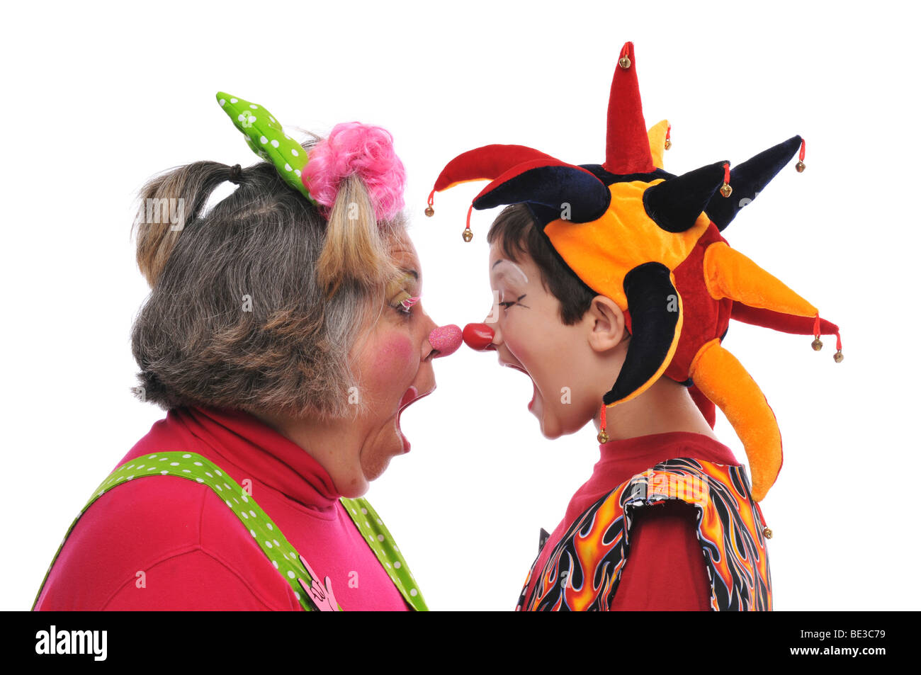 Two clowns facing each other and screaming against a white background ...