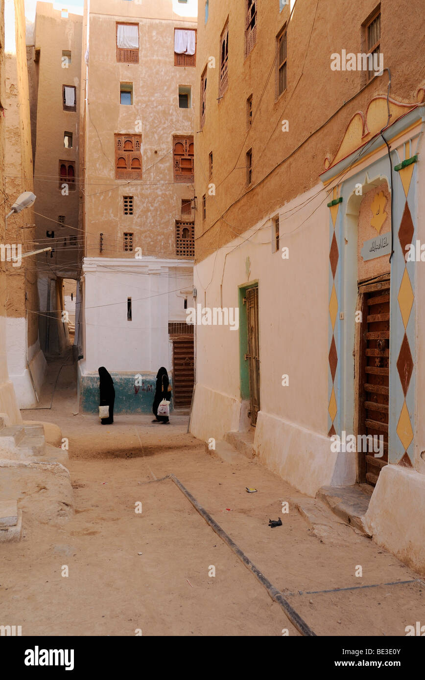 Arabian women in a narrow lane in the historic adobe old town of Shibam ...