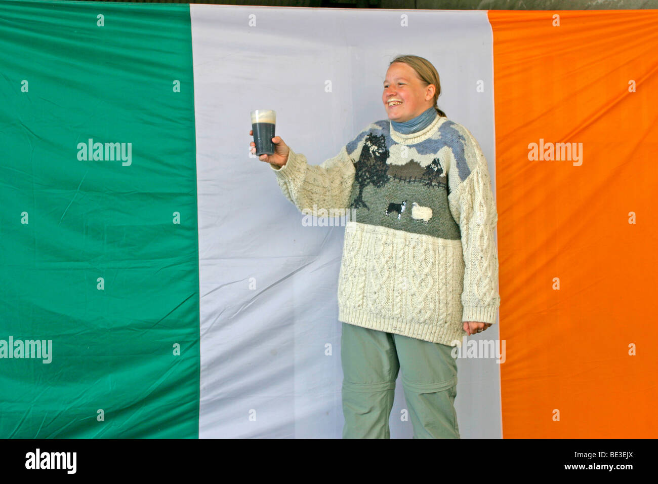 portrait of a young woman drinking a pint of Guinness in front of the ...