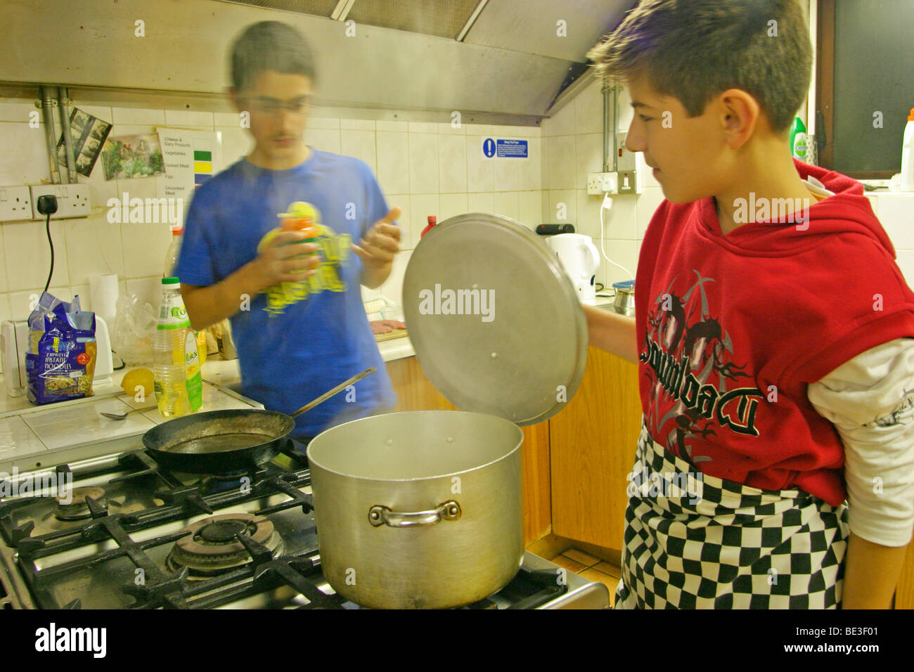 two young boys cooking a meal at a youth hostel in County Donegal ...