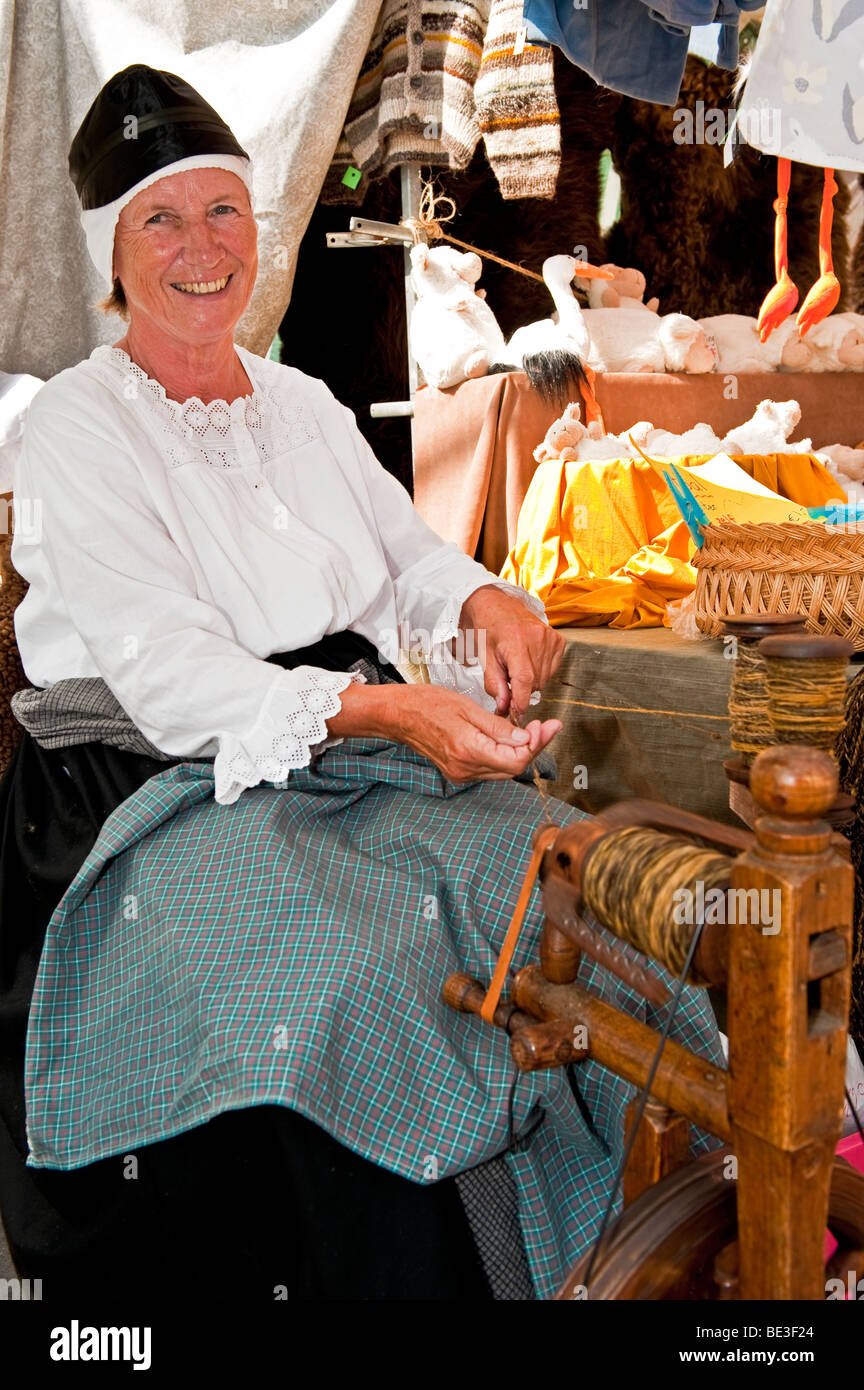 A lady using a spinning wheel Stock Photo - Alamy