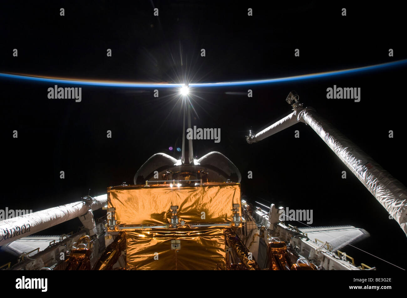 Space Shuttle Atlantis' payload bay backdropped by a blue and white ...
