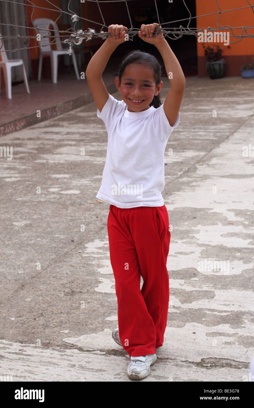 Portrait of a little girl smiling in the schoolyard hanging on a ...