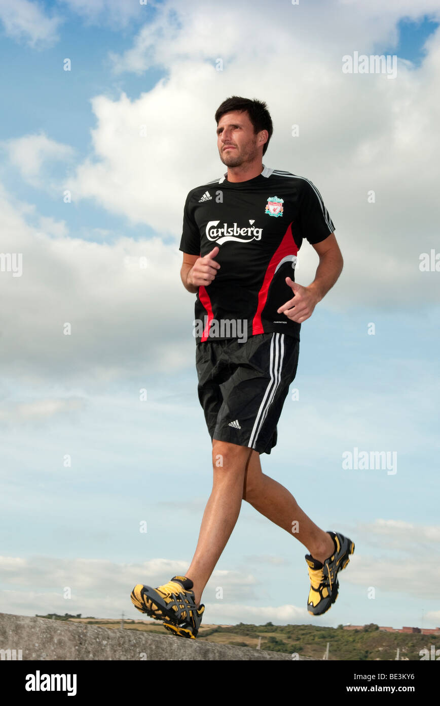man running in football kit Stock Photo - Alamy