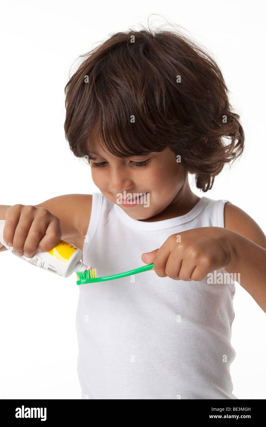 Little boy is putting a toothpaste on his toothbrush Stock Photo - Alamy