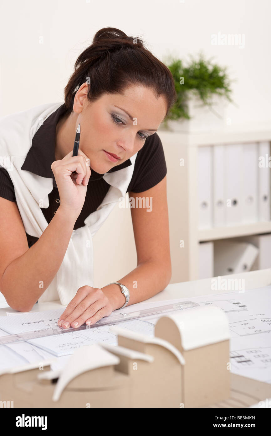 Successful architect woman at the office with plans and architectural ...