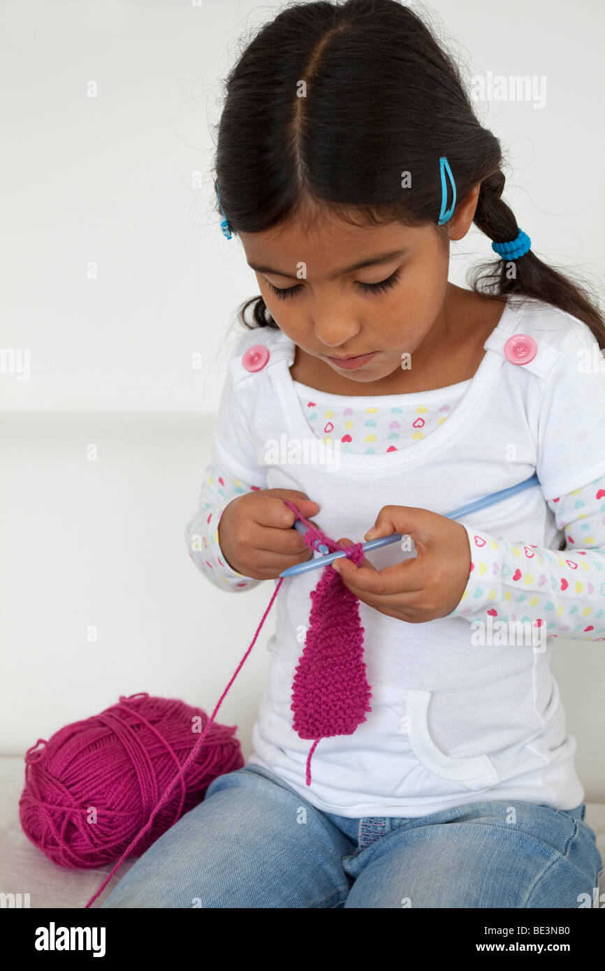 Little girl is knitting a tie Stock Photo - Alamy
