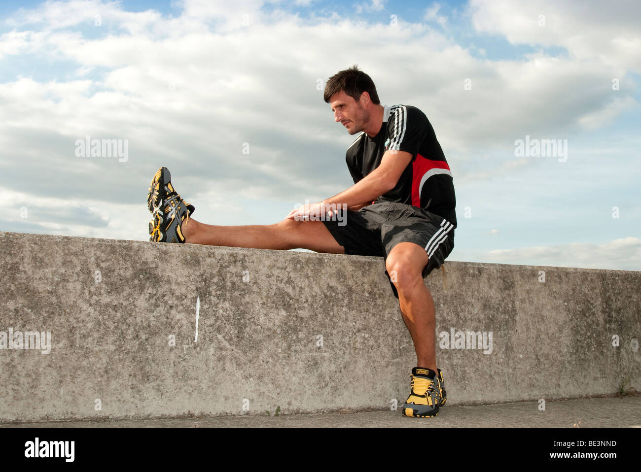 man stretching muscles in leg Stock Photo - Alamy