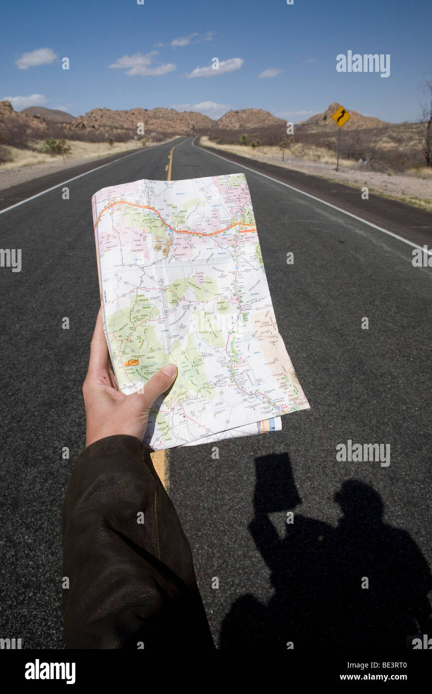 A hand holding a map on a deserted desert highway in Arizona Stock ...