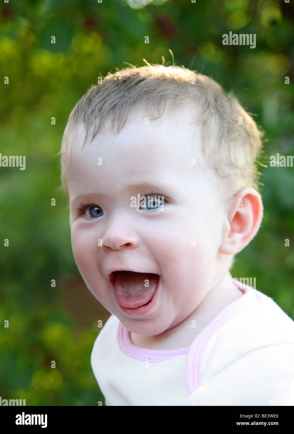happy laughing baby outdoor on green background Stock Photo - Alamy