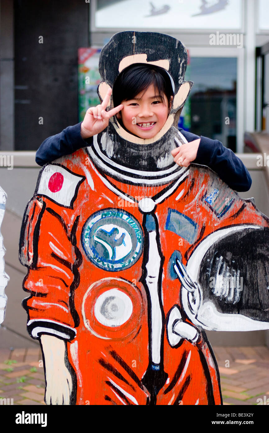 A young girl poses in a cardboard cut-out space suit at the Yoichi ...