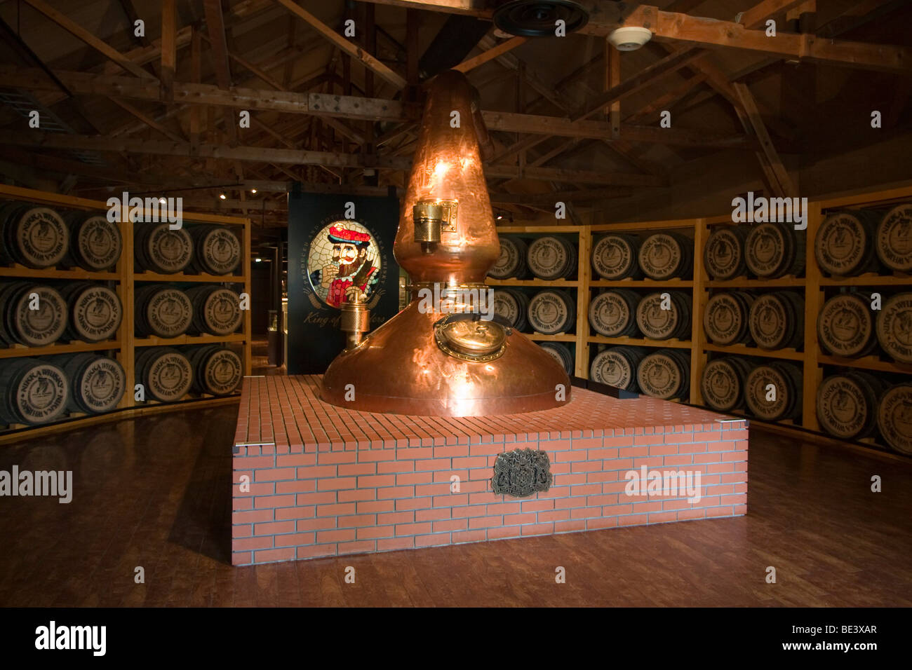 A large mixing vat and wooden casks of whiskey on display at the Nikka ...