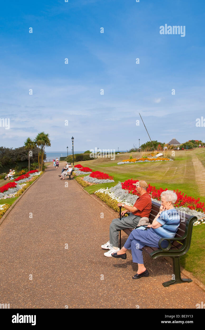 Two pensioners sitting on a seafront bench looking out to sea at ...