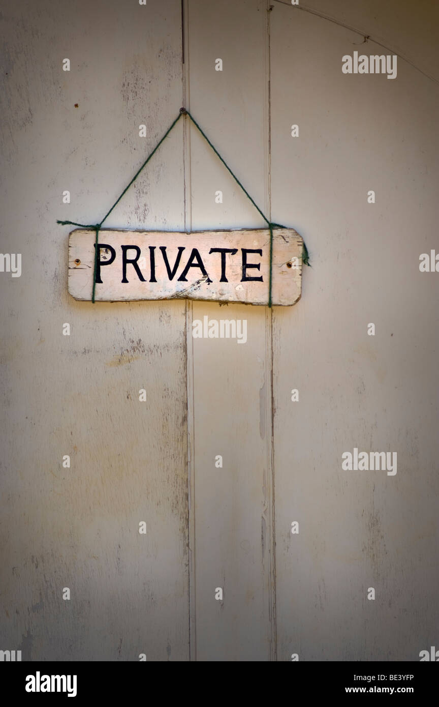 private sign hanging by string on flaking white painted door Stock ...