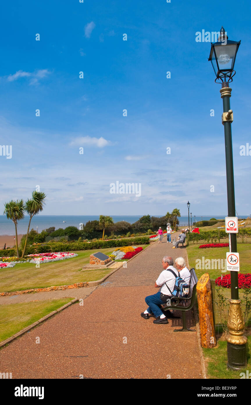 Two pensioners sitting on a seafront bench looking out to sea at ...