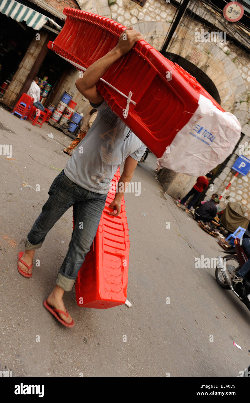 vietnamese worker carrying bunch of plastic chair for sale in old ...