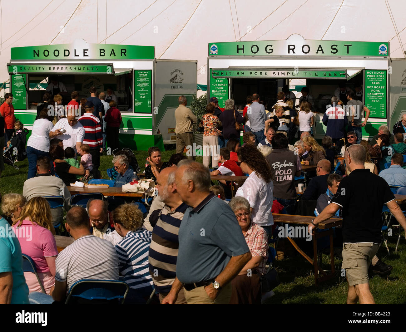 Crowds of people queuing for lunch at a Noodle Bar and Hog Roast at ...