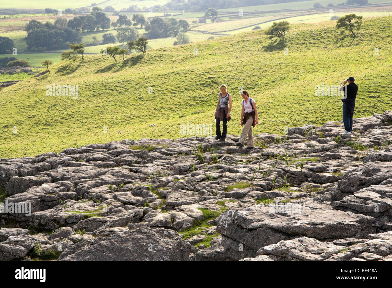 Walkers at the top of Malham Cove, Malhamdale, Yorkshire Dales, England ...