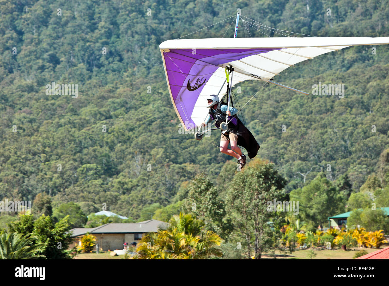Hang glider against blue sky coming into land Stock Photo - Alamy
