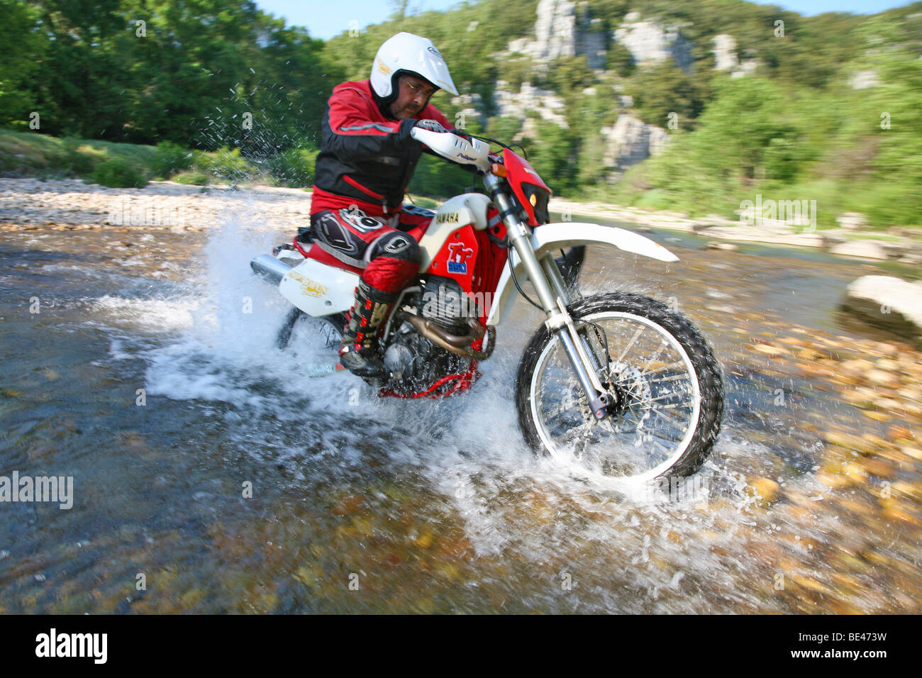 Off-road motorcyclist crossing a river in the south of France, France ...