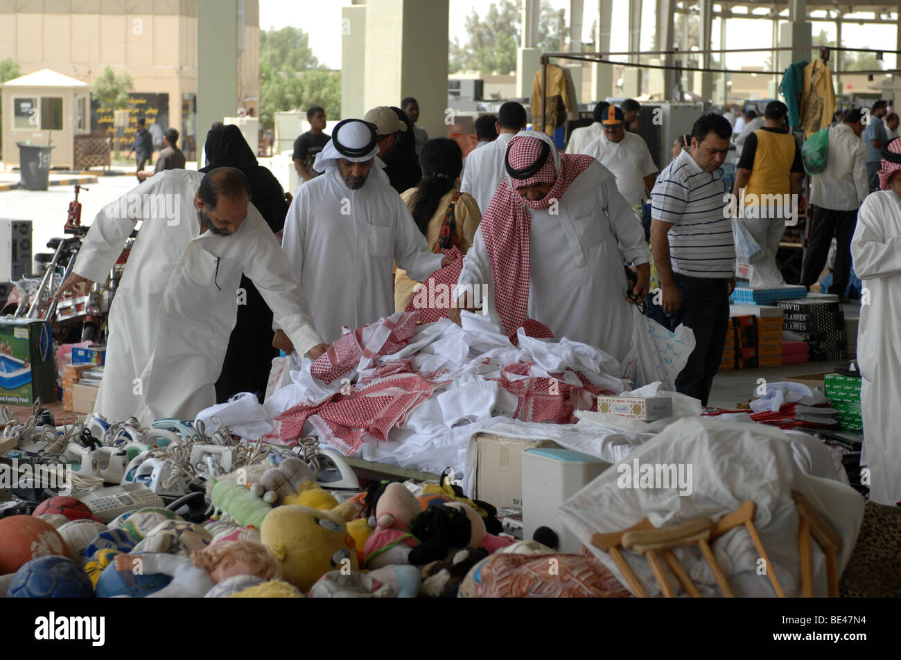 Arab Men wearing traditional Dishdashah look for new Shumagg red and ...