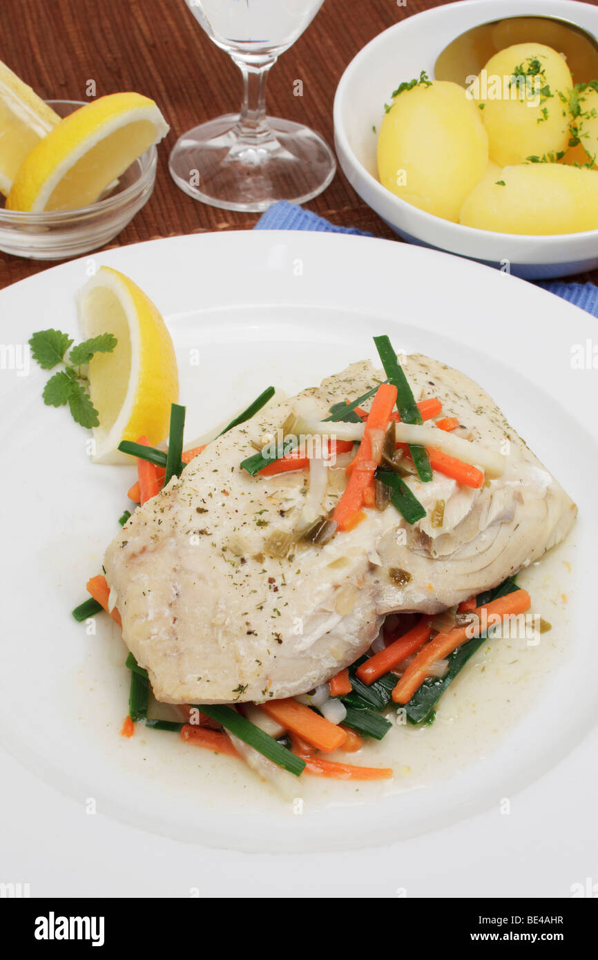Steamed Saithe fillet on a bed of colourful vegetables with boiled ...