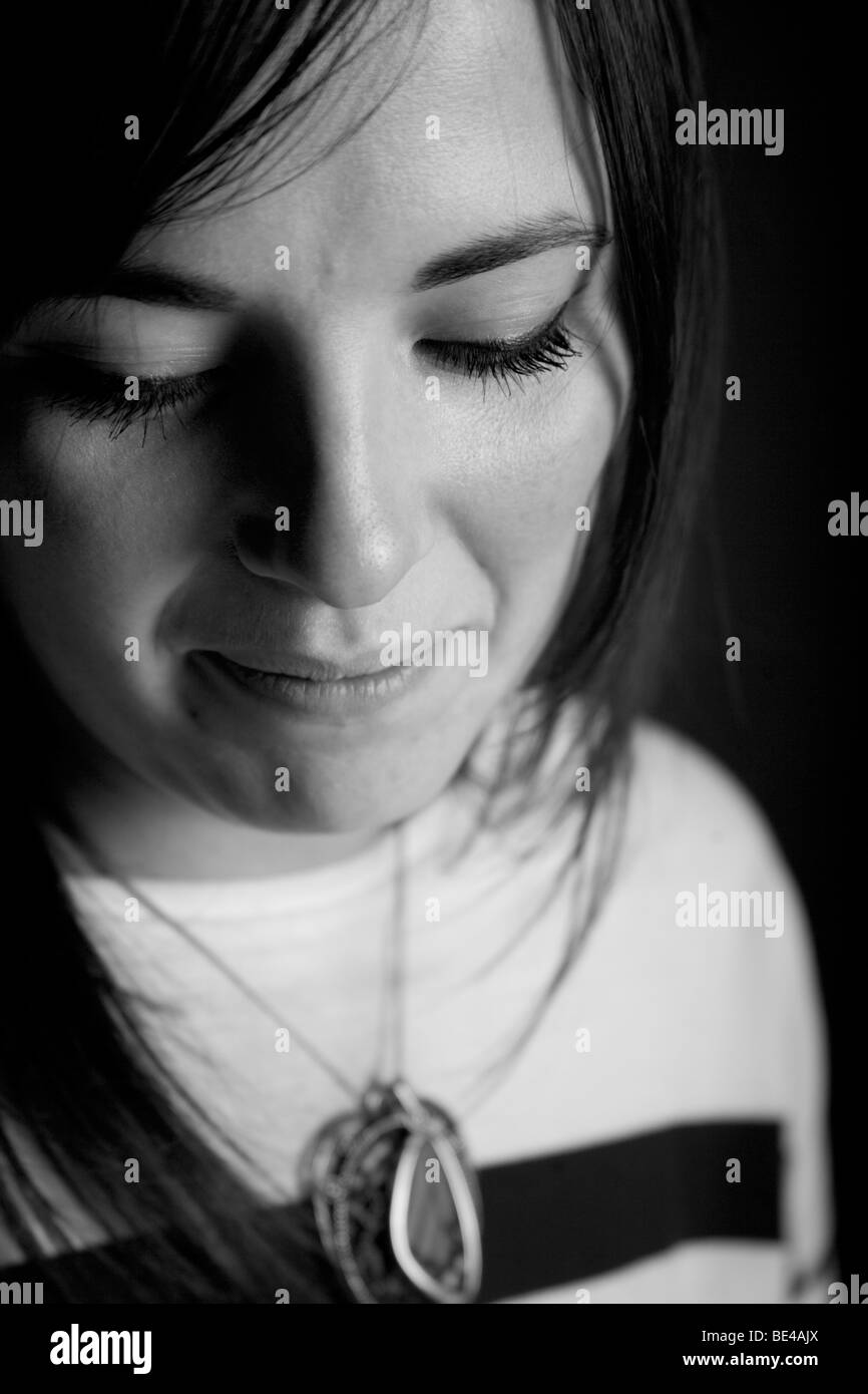 Pretty, young woman with her head low, and eyes almost shut Stock Photo ...