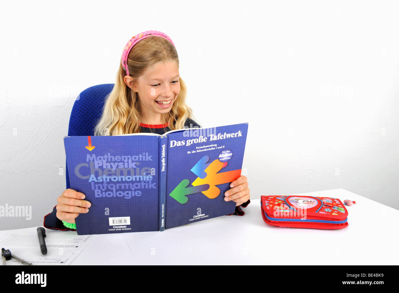 Young schoolgirl reading happily in a textbook Stock Photo - Alamy