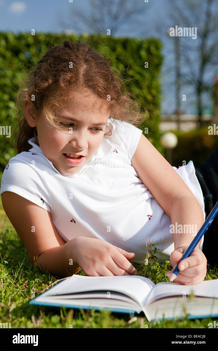 Schoolgirl doing homework outside in the garden Stock Photo - Alamy