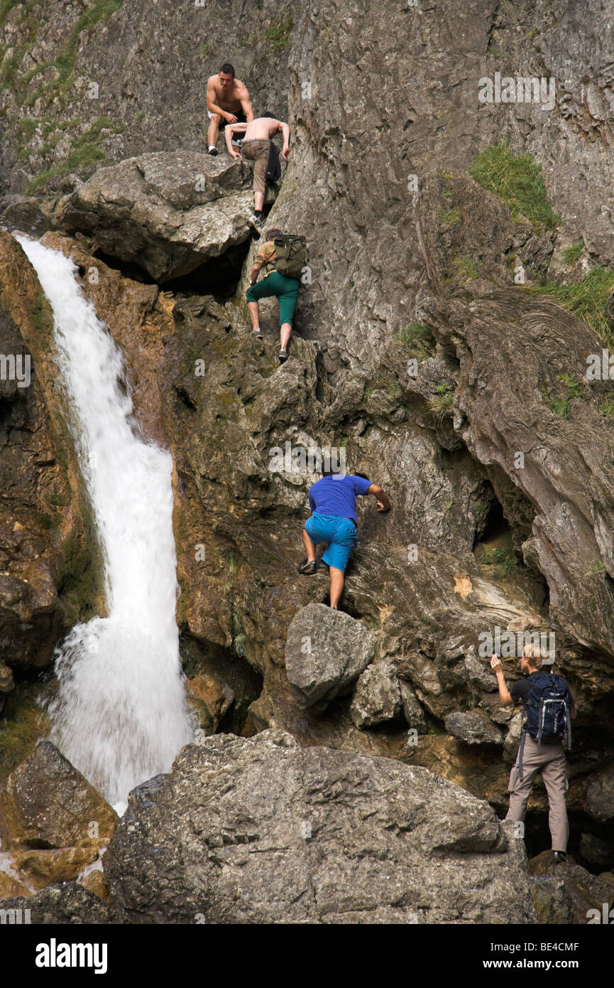 People climbing a waterfall, Gordale Scar, near Malham, Yorkshire Dales ...
