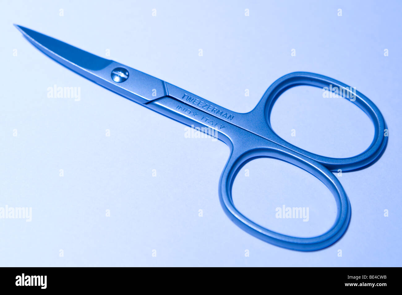 Scissors on a blue background Stock Photo - Alamy