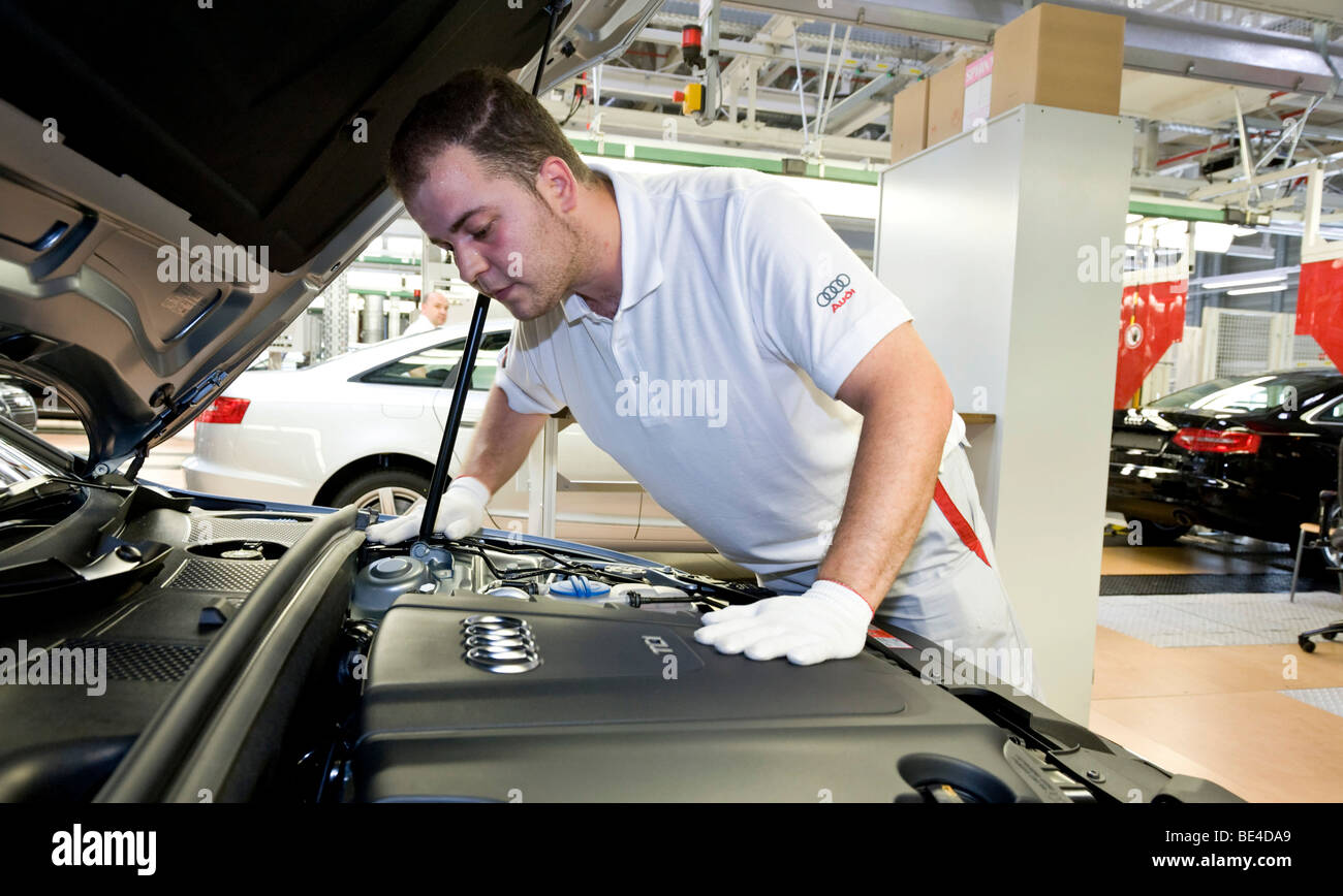 An Audi employee is checking an Audi A4 sedan for possible faults at ...