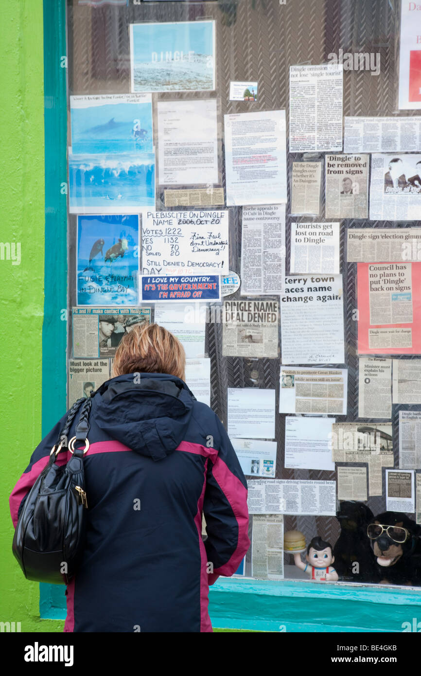 Woman reading notices in a shop window Stock Photo - Alamy