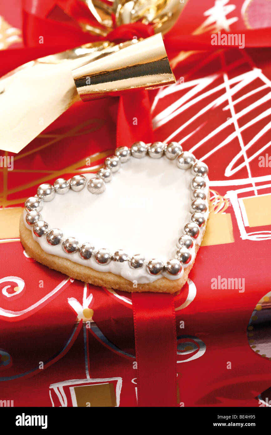 Heart-shaped short pastry biscuit with sugar icing and silver sugar ...