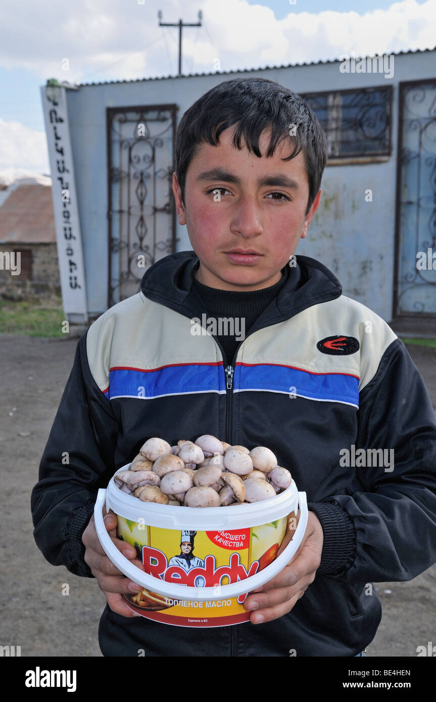 Armenian boy selling mushrooms in a poor mountain village near Sisian ...