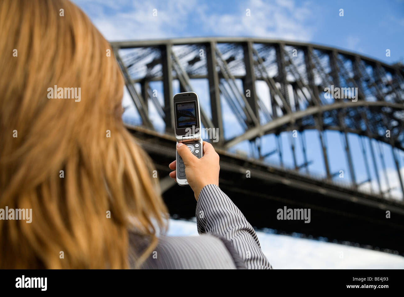 Businesswoman taking picture of Sydney Harbour Bridge on a mobile phone ...