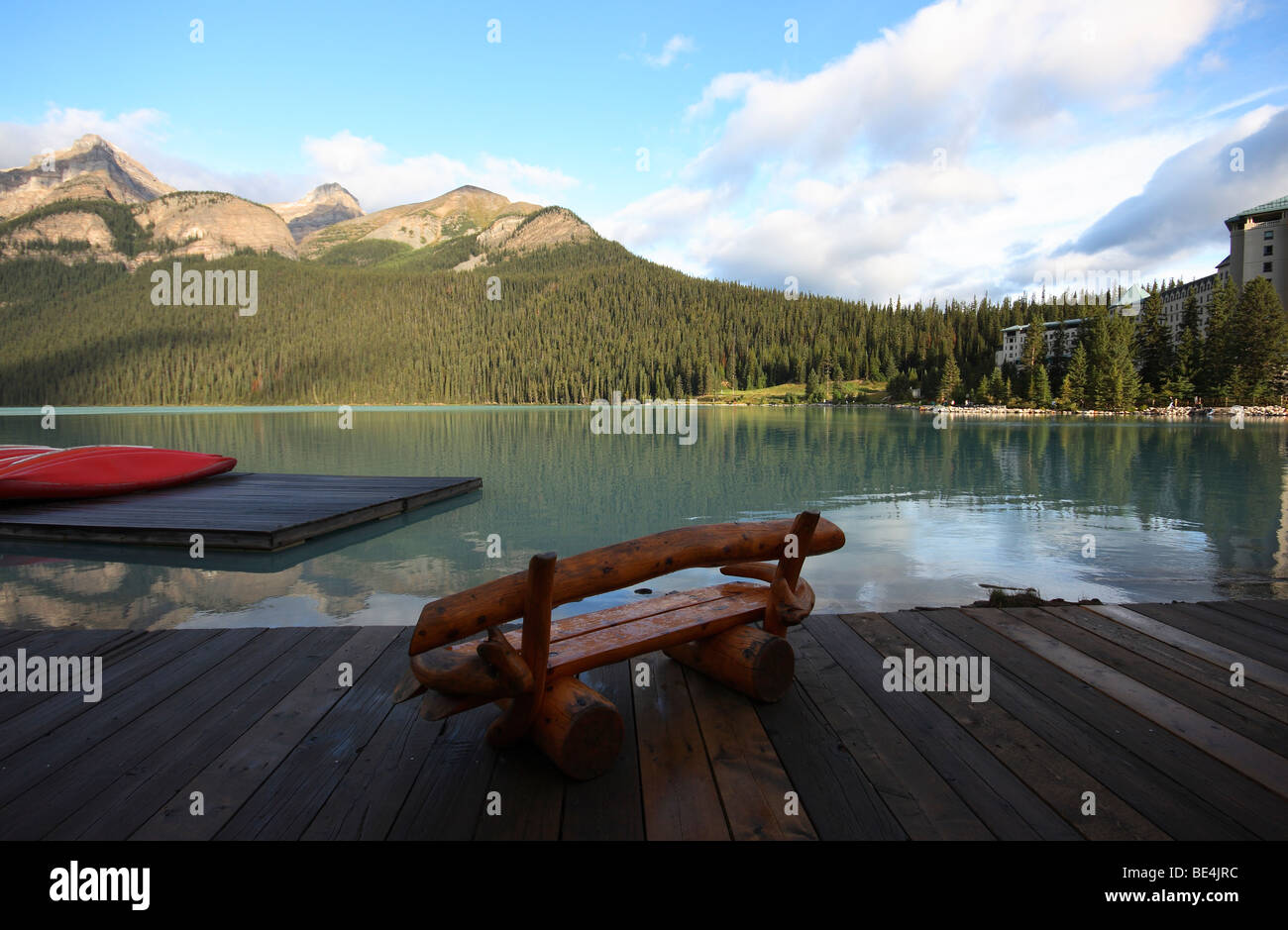 Wooden bench in front of lake Louise with red canoes ,Banff national ...