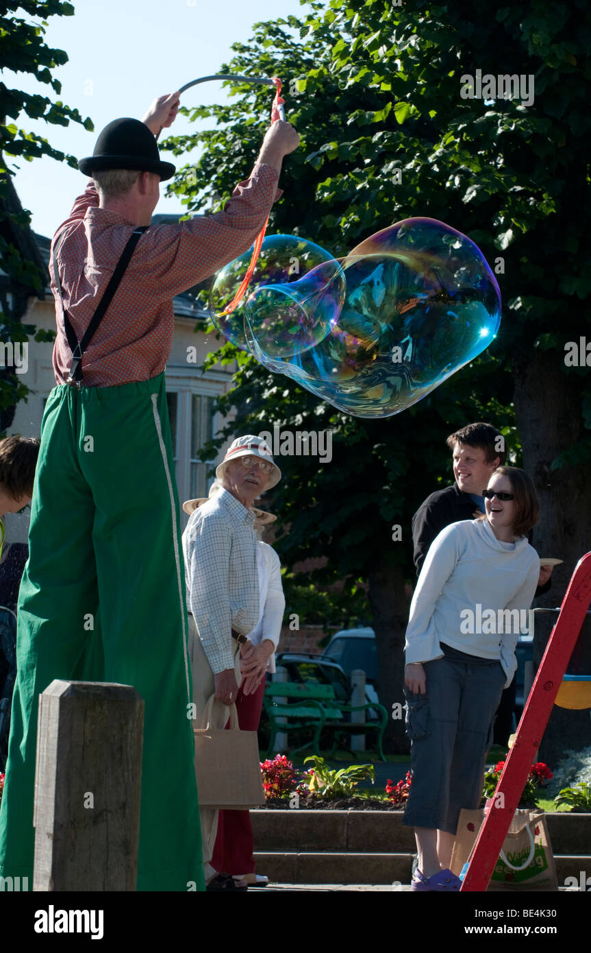 A stilt walker makes large bubbles for visitors to Ludlow Food Festival ...