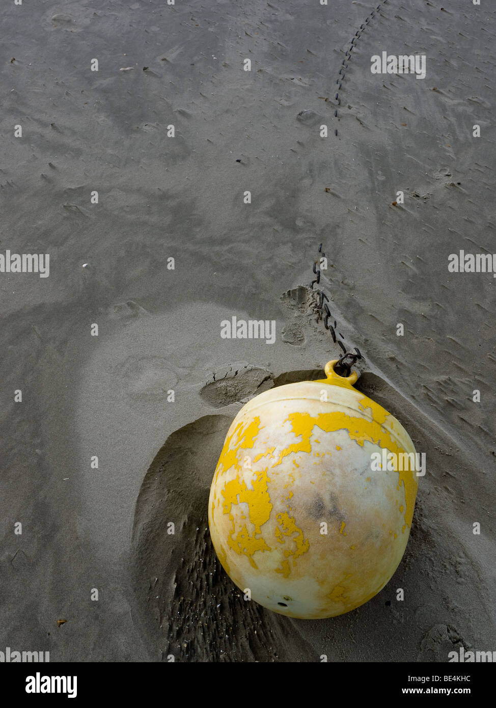 A yellow buoy at rest on the sand of a French beach Stock Photo - Alamy