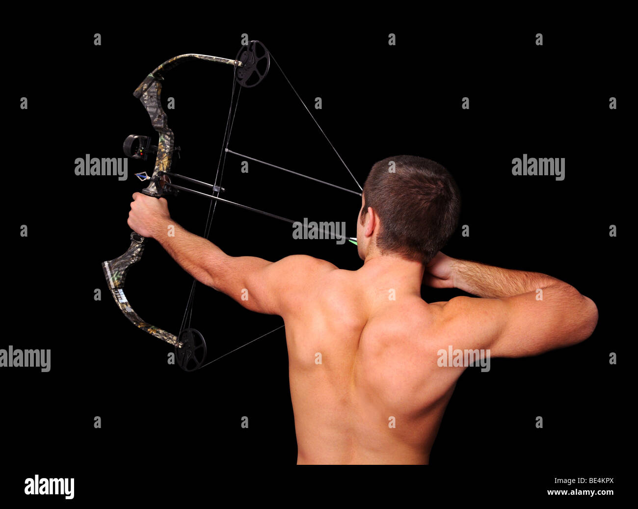 Young archer with bow and arrow aiming high isolated over a black ...