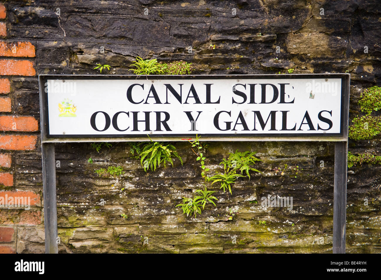 CANAL SIDE bilingual ENGLISH WELSH street sign against stone wall at ...
