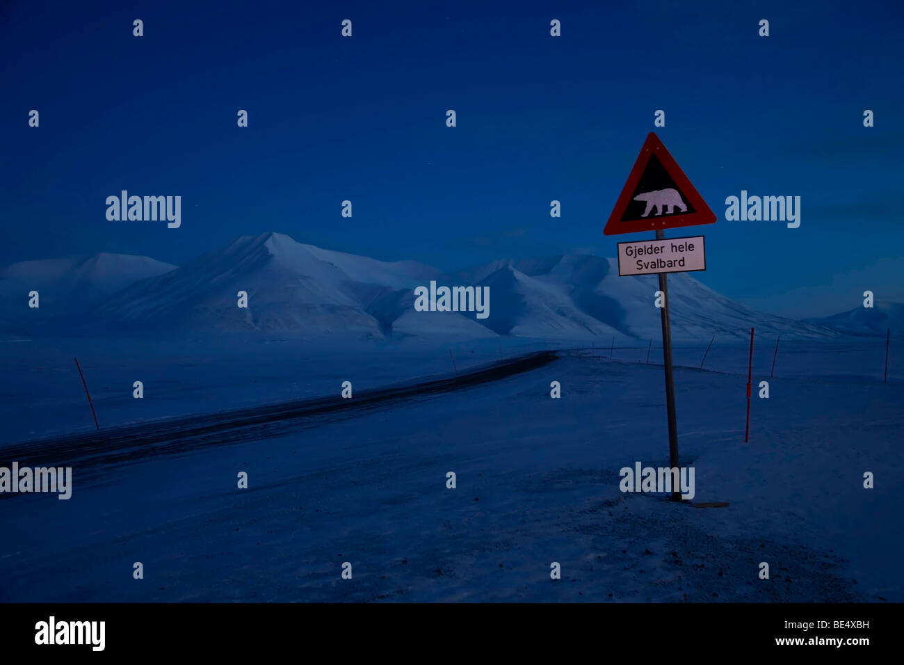 Road sign with a polar bear and mountains in the polar night in ...