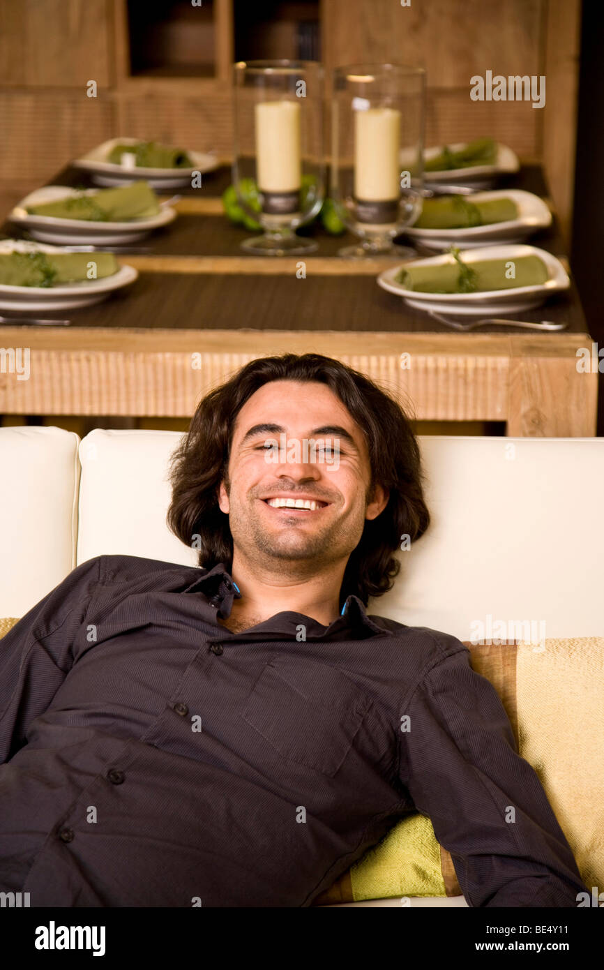 Young man waiting for guests, in front of laid table Stock Photo - Alamy