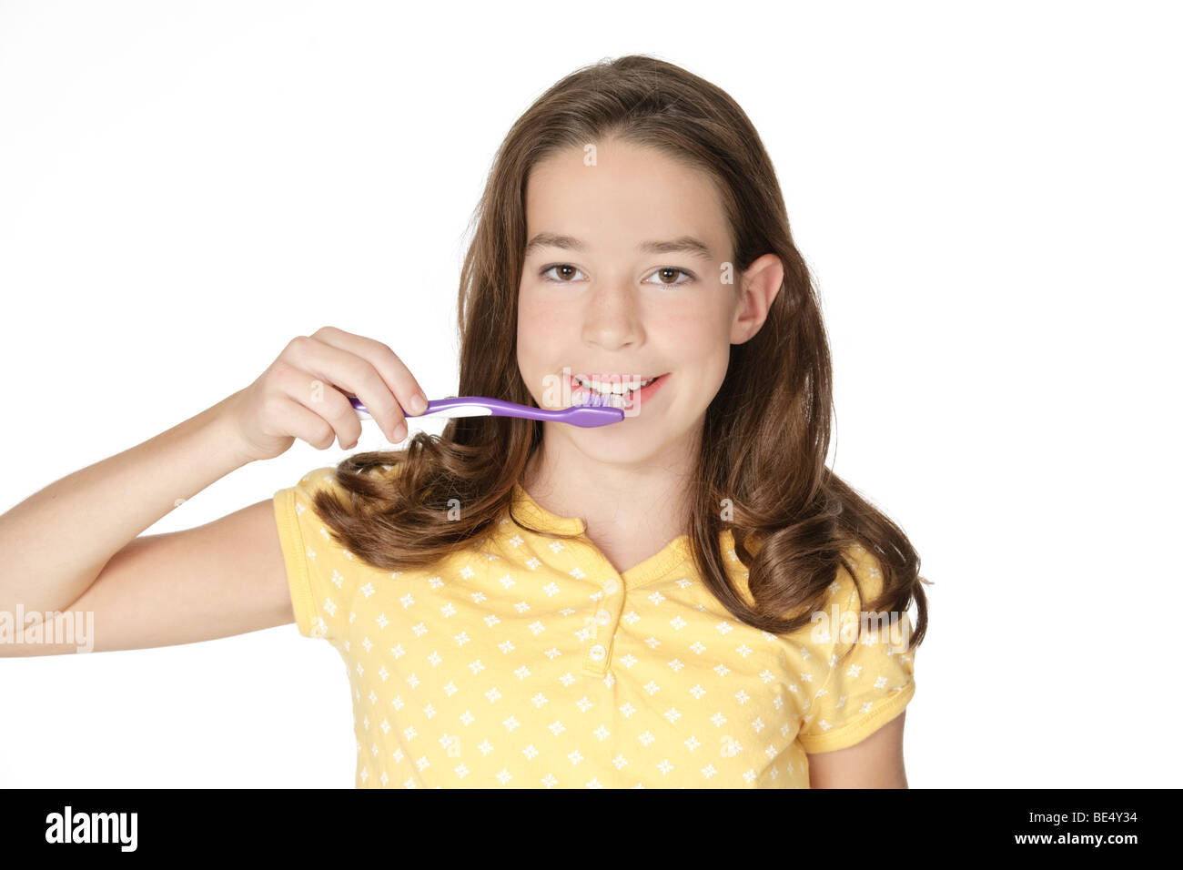 Cute Caucasian girl brushing her teeth isolated on a white background ...
