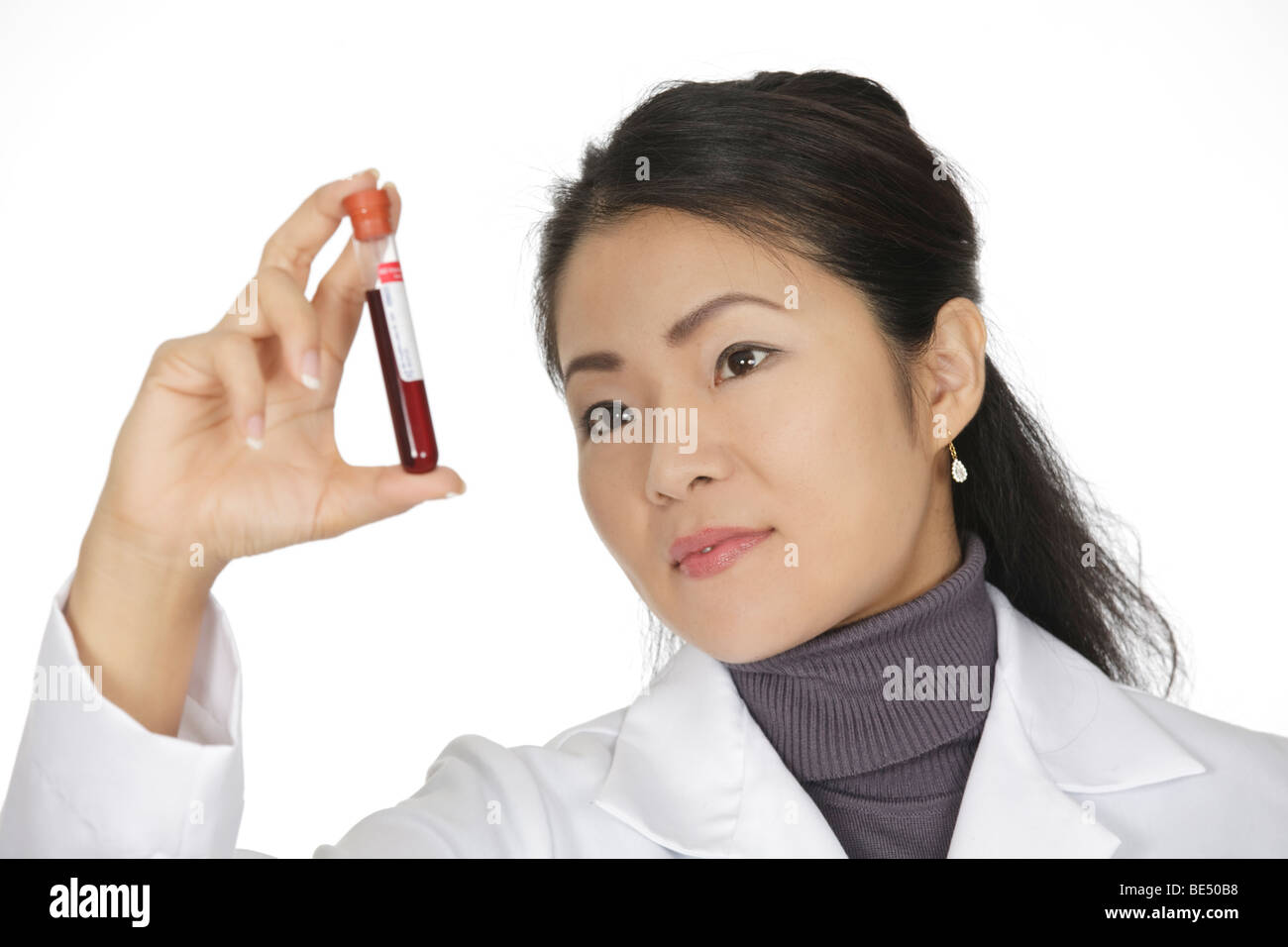 Beautiful Asian laboratory technician examining a tube of blood Stock ...