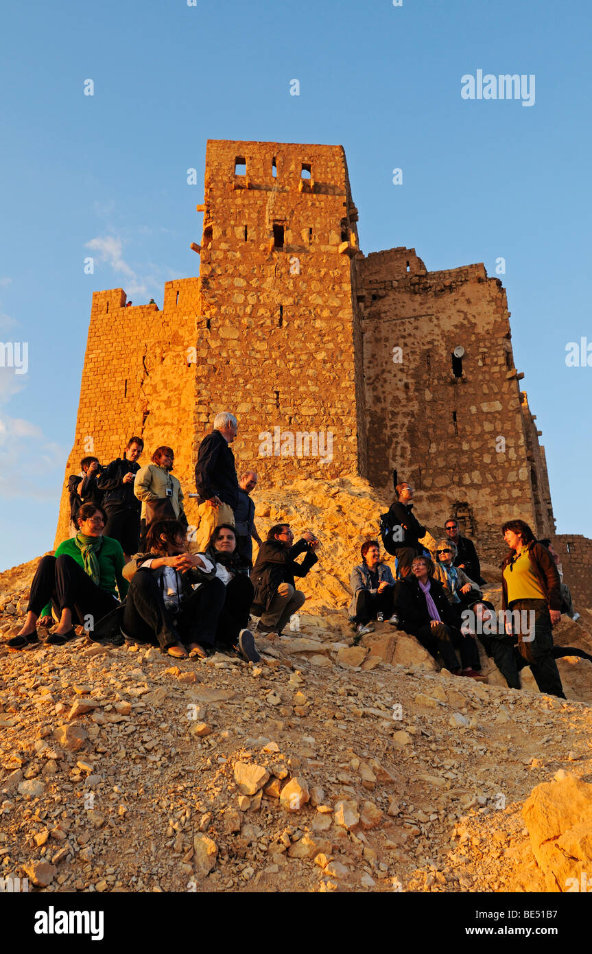 Tourists at sunset in front of the castle Qala'at Ibn Ma'n, Palmyra ...