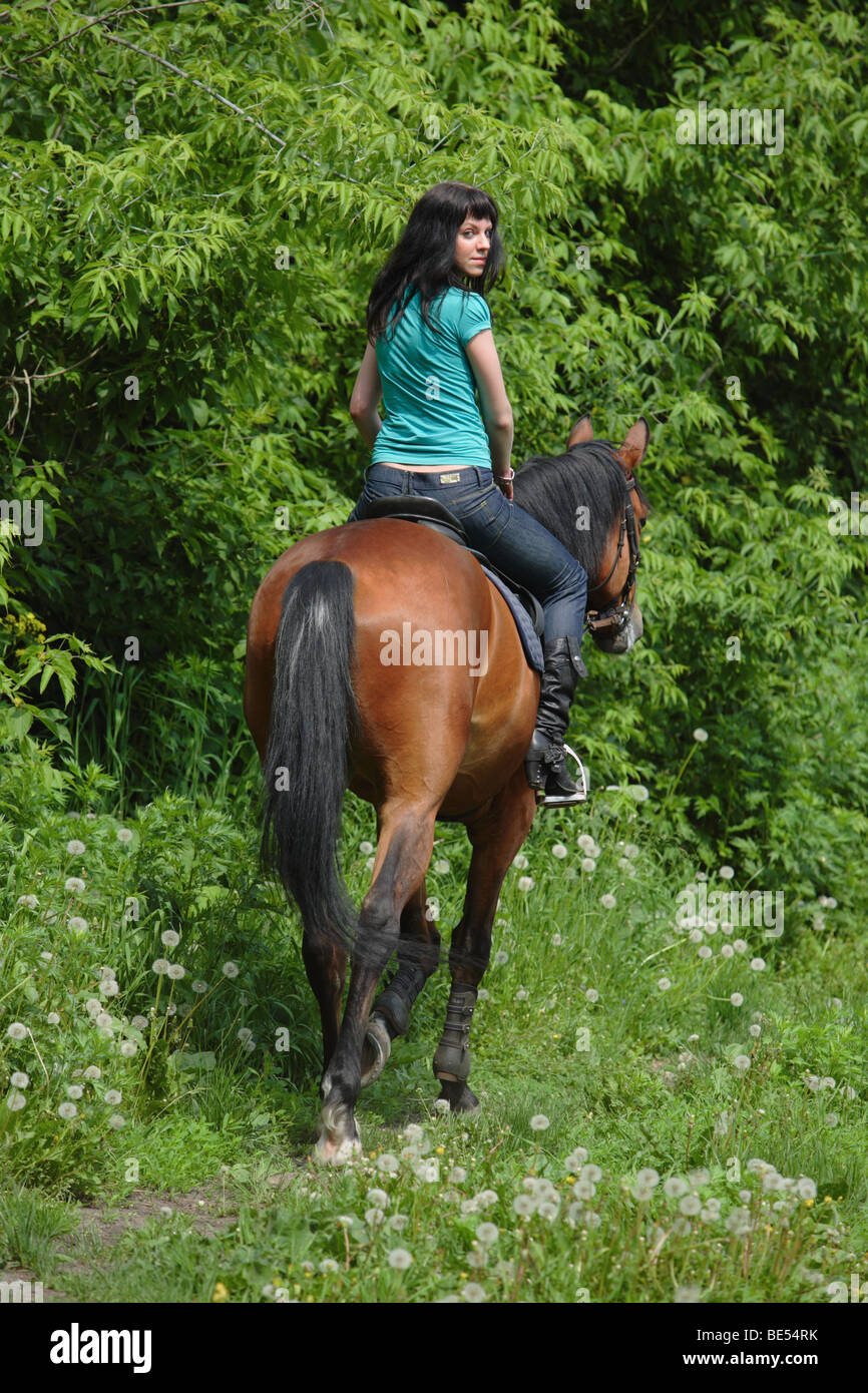 Young woman horseriding on a forest road in Russia Stock Photo - Alamy
