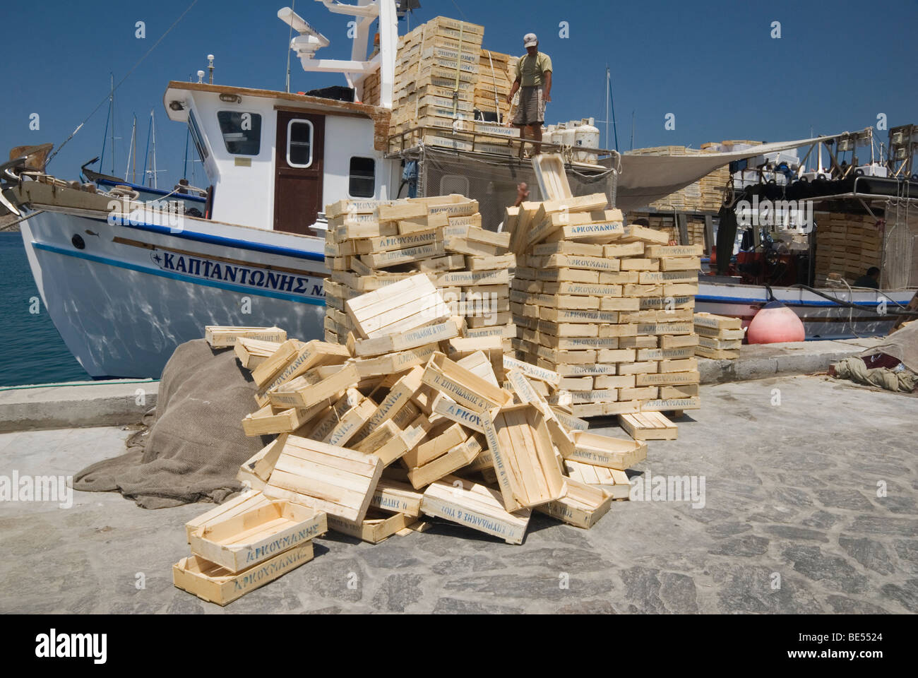 Men loading empty crates on a fishing boat in Greece Stock Photo - Alamy