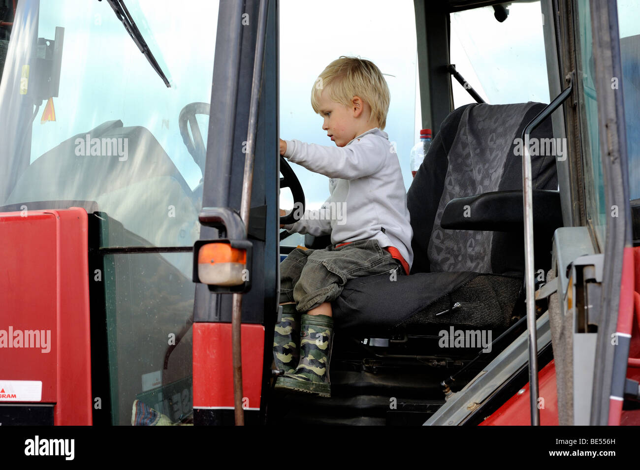 Child blond Boy driving a vintage tractor engine Stock Photo - Alamy