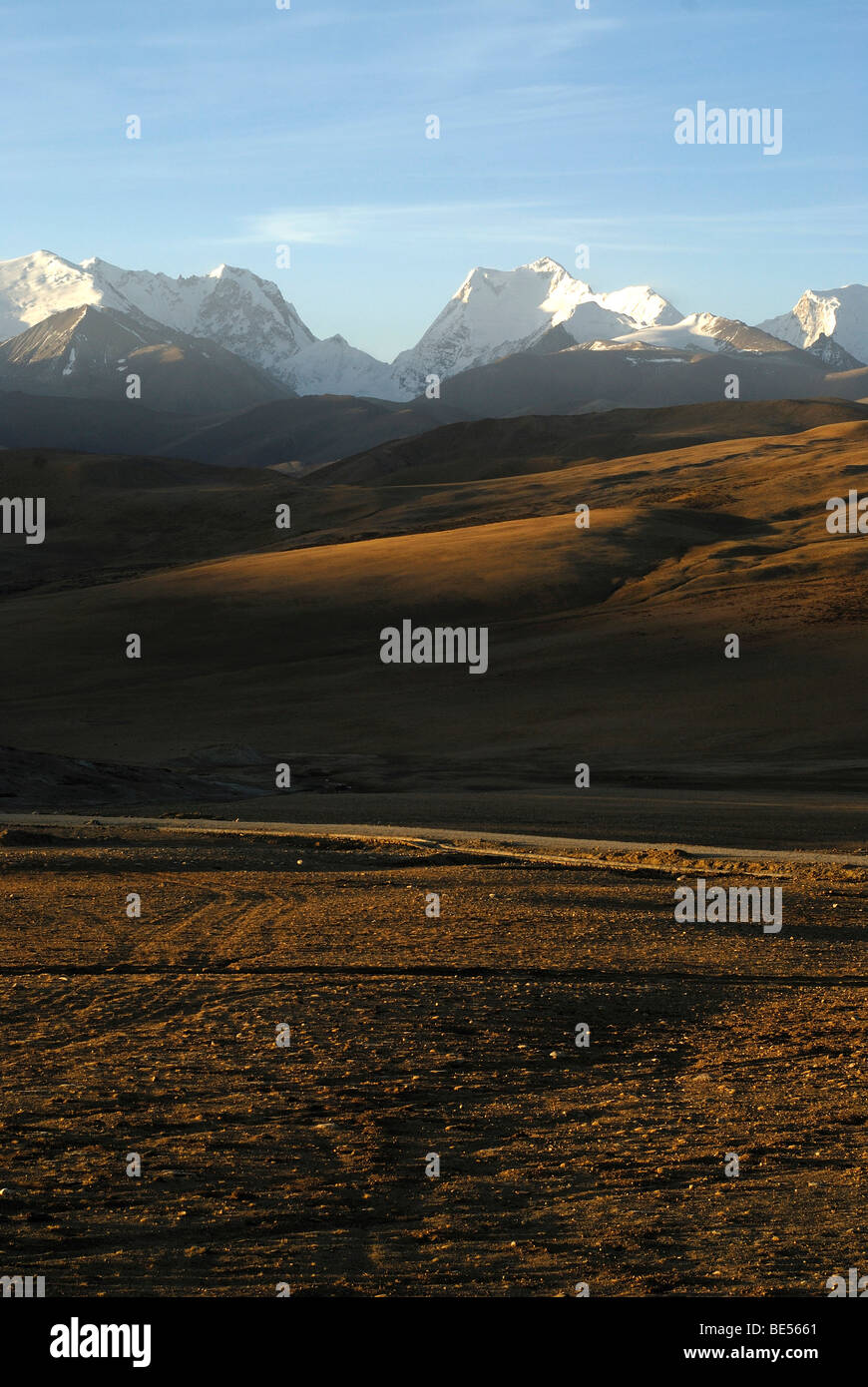 Snowy main ridge of the Himalayas with mountain road in the morning sun ...